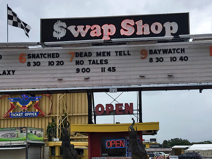 The iconic Swap Shop sign doubles as a drive-in movie marquee—because why choose between bargain hunting and catching the latest blockbuster when you can do both?