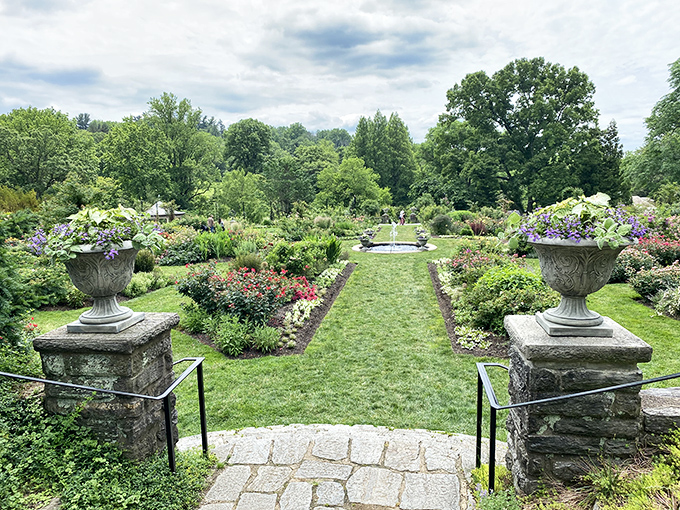 Stone urns stand like elegant sentinels guarding this emerald runway of perfectly manicured grass, inviting you down a path that practically screams "sophistication ahead!"