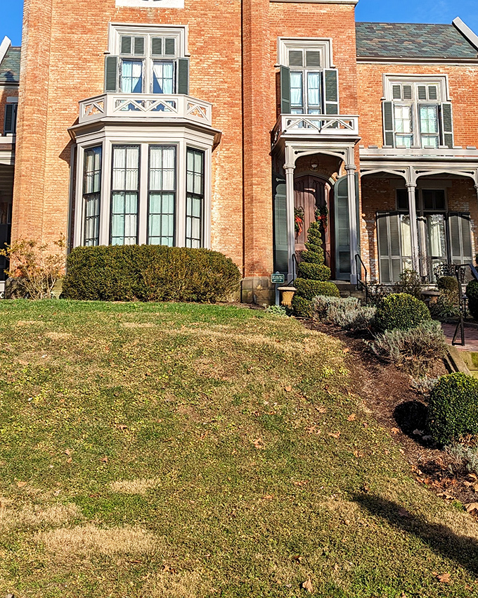 The grand entrance to The Castle beckons through ornate iron fencing, promising Victorian splendor behind those brick walls. History never looked so inviting!