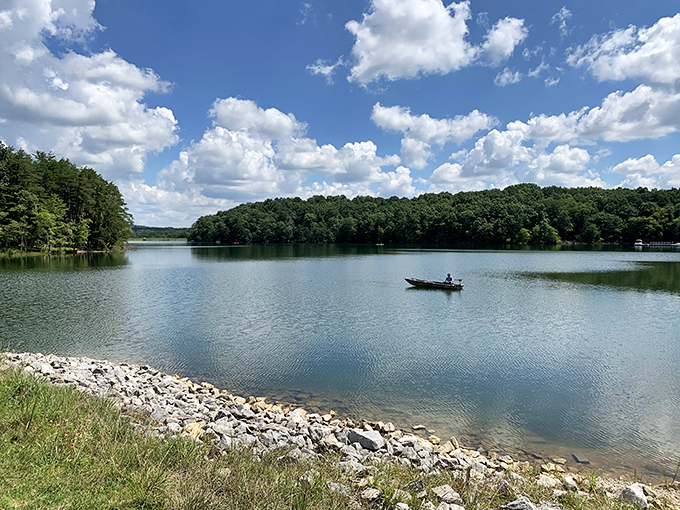 A lone fisherman finds solitude on Fall Creek Falls Lake, where the boundary between water and sky blurs into a perfect Tennessee afternoon.
