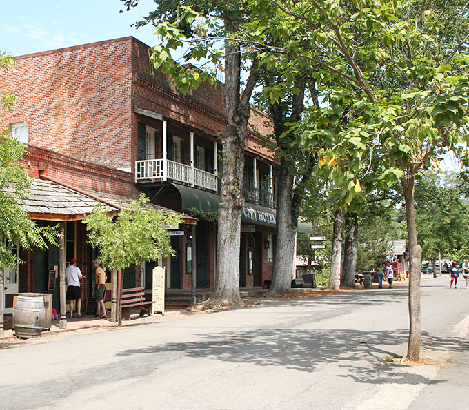 The City Hotel stands as Columbia's brick sentinel, its balconies and wooden awnings offering shade to visitors stepping back in time on these historic streets.