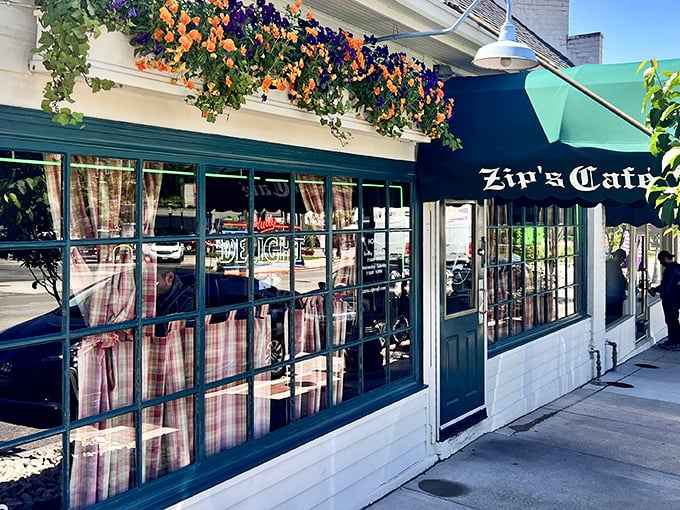 Colorful flower baskets frame Zip's charming storefront, proving that sometimes the best meals hide behind the most unassuming facades.