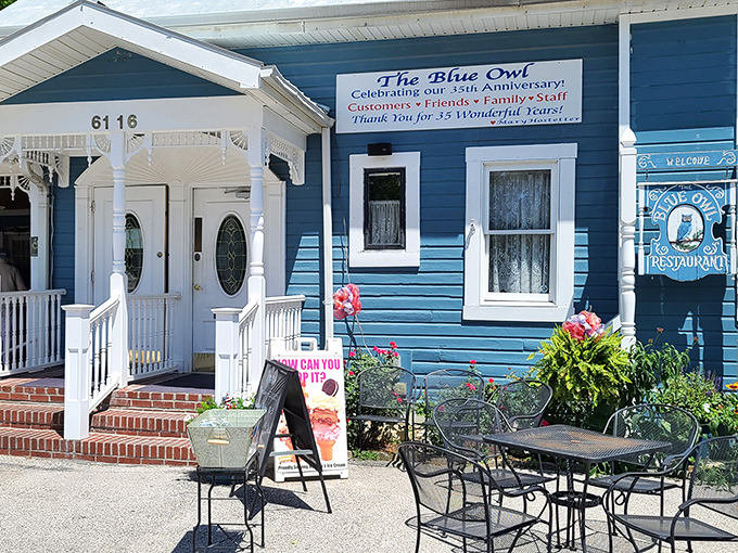 The charming blue clapboard exterior welcomes visitors like an old friend, complete with white trim and a front porch that practically whispers "come sit a spell."