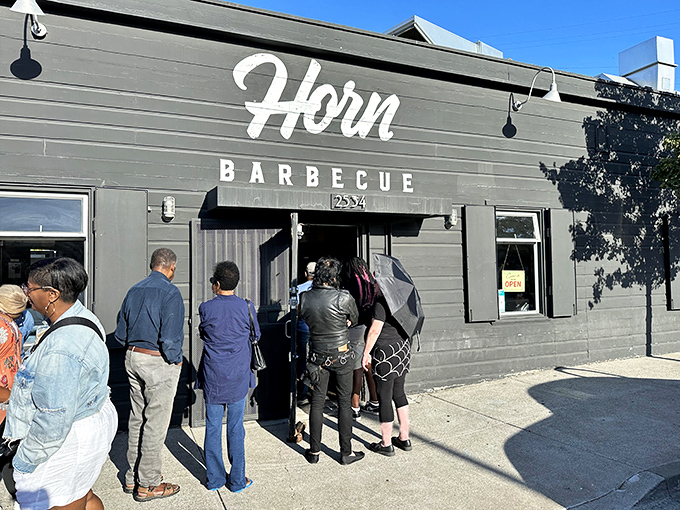 The black building with its bold bull mural stands like a smoke signal to barbecue pilgrims. This unassuming corner spot in Oakland houses meat magic worth the journey.
