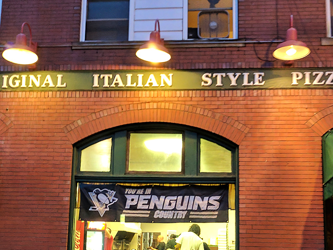 The iconic brick fa&ccedil;ade of Police Station Pizza glows warmly at dusk, its "Original Italian Style Pizza" sign a beacon for hungry Pennsylvanians.
