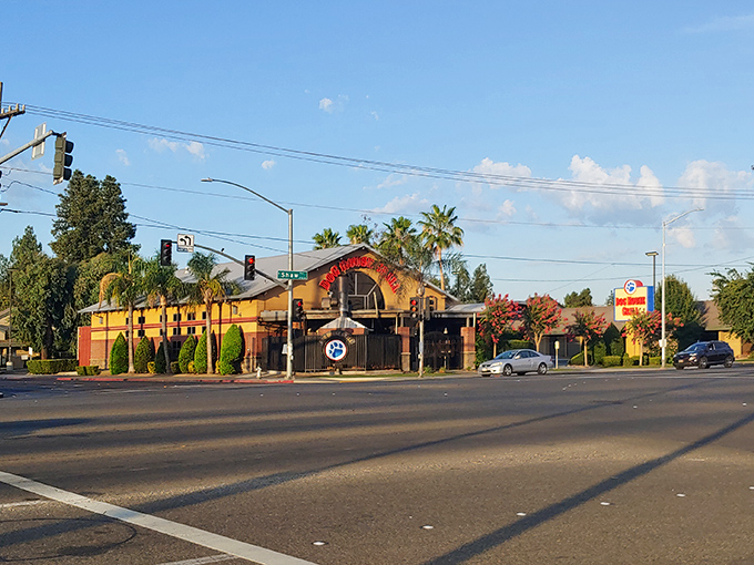 A California sunset casts a golden glow on Dog House Grill's exterior, where palm trees and promise of perfect tri-tip sandwiches await.