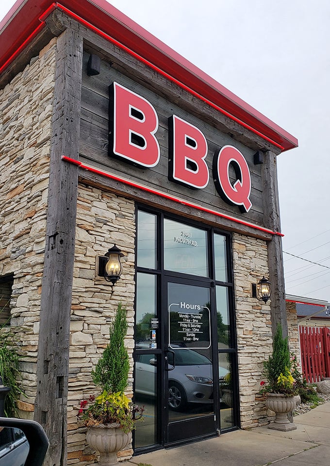 The stone facade and bold BBQ sign promise what every barbecue pilgrim seeks &ndash; authentic smoke and soul in suburban Michigan.