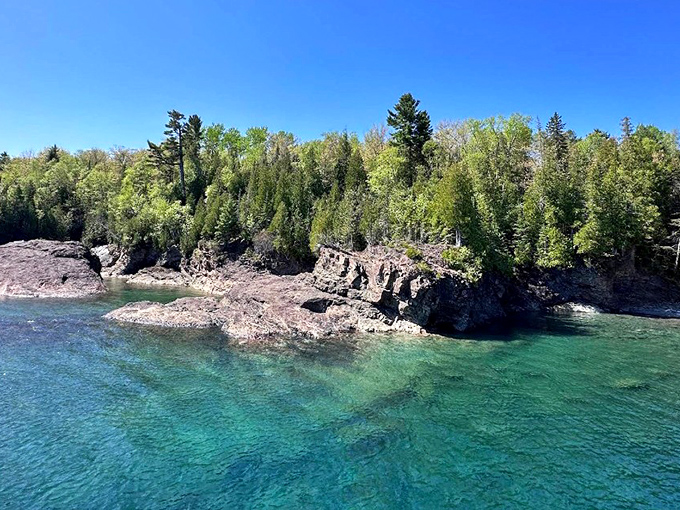 Lake Superior's emerald waters frame these ancient volcanic rocks like nature's own jewelry display.