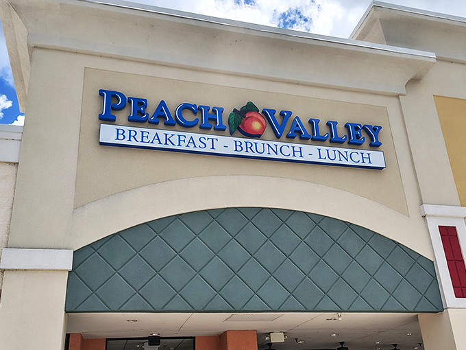 The welcoming facade of Peach Valley Cafe beckons breakfast enthusiasts with its cheerful signage and promise of morning delights that outshine Orlando's flashier attractions.