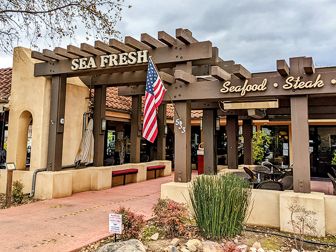 The welcoming pergola at Sea Fresh beckons like an old friend, promising seafood treasures under that rustic wooden frame and California sunshine.