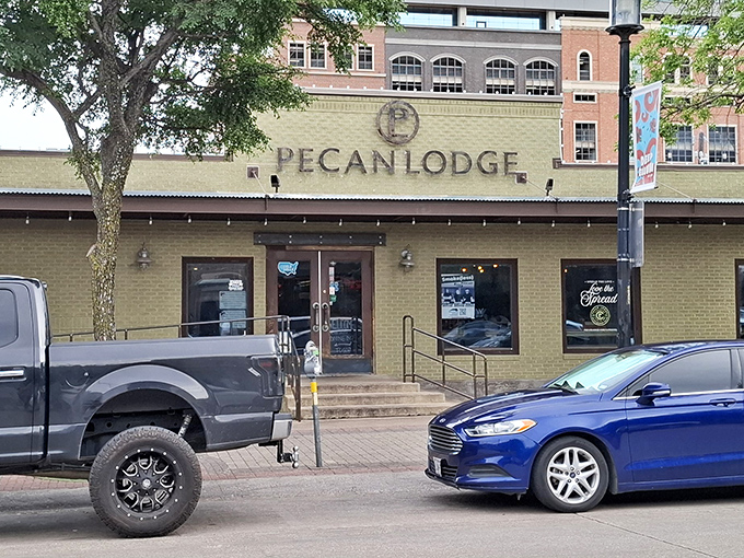 The unassuming brick exterior of Pecan Lodge belies the smoky magic happening inside. Like a barbecue speakeasy hiding in plain sight