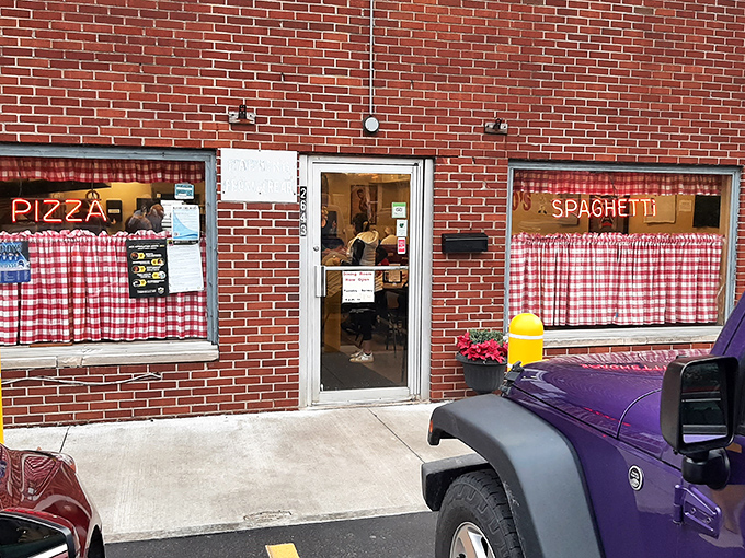 The unassuming brick exterior of Rubino's Pizza in Bexley hides culinary treasures that locals have cherished for generations. Those red-checkered curtains promise authentic Italian-American comfort.