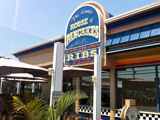 The iconic blue sign of The Little House of Pancakes stands like a beacon for breakfast lovers, promising pancakes, ribs, and culinary happiness.