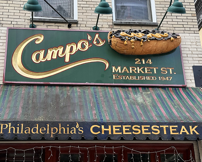Campo's iconic blue awning and vintage signage stand as a beacon of sandwich perfection in Philadelphia's historic district, promising authentic cheesesteak bliss since 1947.