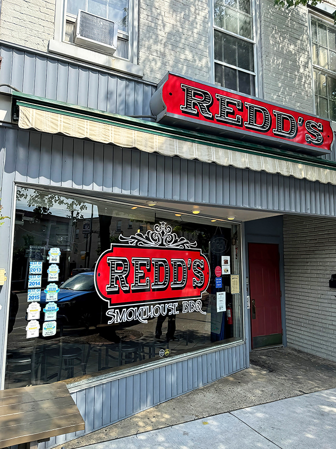 That bold red sign against the blue-gray exterior is like a beacon calling to hungry travelers. BBQ paradise awaits inside!