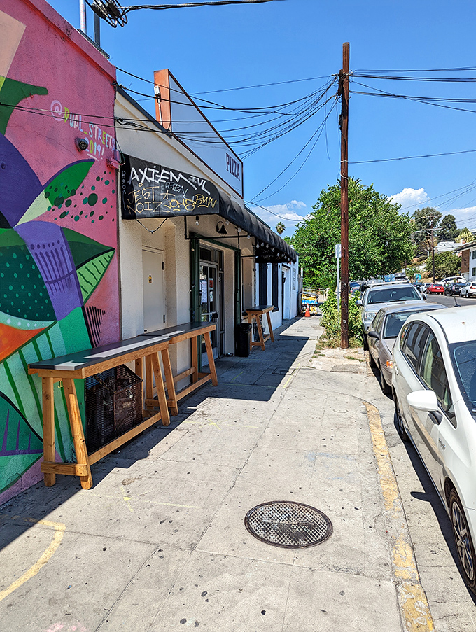 The unassuming exterior of Quarter Sheets hides culinary greatness behind a vibrant mural, like finding a Picasso at a yard sale.