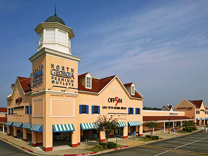 The iconic clock tower of North Georgia Premium Outlets stands tall against a blue Georgia sky, like a retail lighthouse guiding bargain hunters to shopping salvation.
