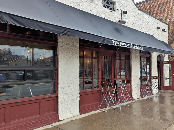 The iconic yellow facade and red awning of The Bread Company stands like a beacon of culinary hope on Urbana's Goodwin Avenue.