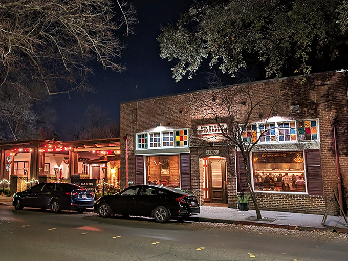 As night falls, this unassuming brick building transforms into a beacon for beef lovers, its warm glow practically whispering "come get your steak on."