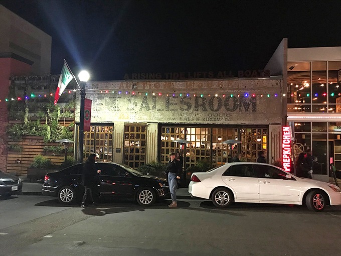 The weathered facade of Ironside Fish & Oyster glows with promise at night, a beacon for seafood lovers in San Diego's Little Italy.