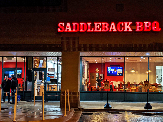 By night, the neon-red glow transforms this strip mall spot into a beacon of barbecue hope, drawing in carnivores like moths to a delicious flame.