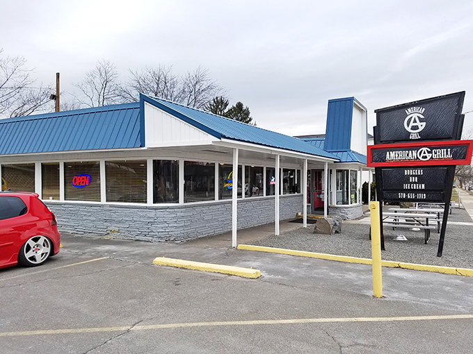 The unassuming blue-roofed exterior of American Grill & BBQ stands like a beacon for hungry travelers. No fancy frills, just the promise of smoke-kissed delights within.
