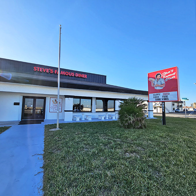 Steve's Famous Diner stands proudly against the Florida sky, its red sign promising "Happy Food, Good Vibes" &ndash; a roadside beacon for hungry travelers.