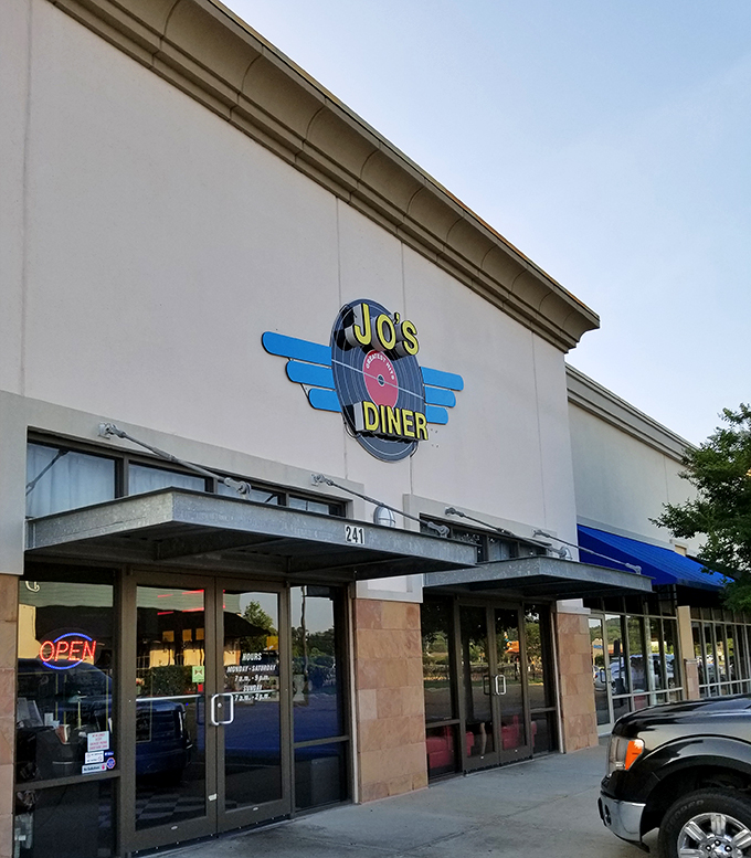 Jo's Diner's retro-styled exterior beckons with its vintage record logo and welcoming neon "OPEN" sign&mdash;like a time portal to simpler, more delicious days.