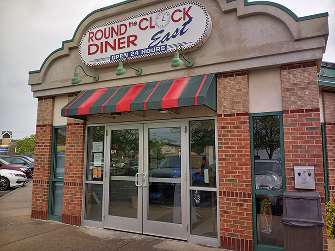 The brick facade and striped awnings of Round the Clock Diner - East stand like a beacon of comfort food promise in York's landscape.