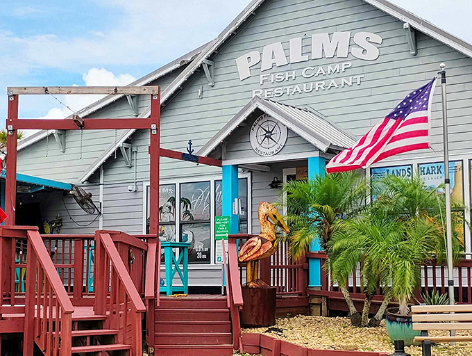 The pale blue exterior of Palms Fish Camp Restaurant beckons like an old friend, complete with wooden deck and American flag fluttering in the coastal breeze.