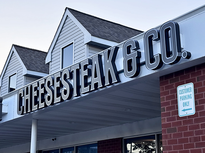 The unassuming storefront boldly proclaims "100% RIB-EYE CHEESESTEAKS" – a siren call to sandwich lovers hiding in plain sight at Rowanberry Center.