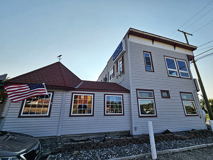 The unassuming exterior of Brennan's Fish House stands like a maritime mirage in Grand River, complete with its distinctive red roof and a proudly waving American flag.