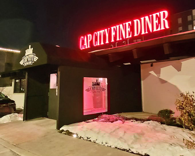 The neon glow of Cap City's sign cuts through the night like a beacon for hungry souls seeking comfort food with a twist.