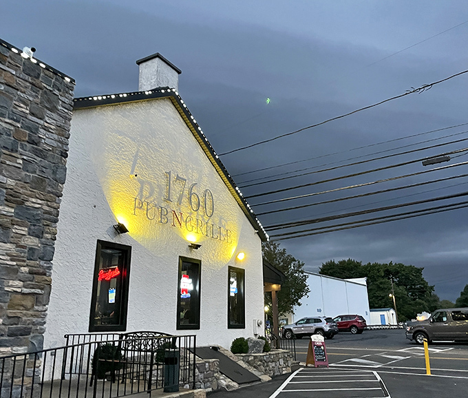 The white-washed exterior with stone accents glows invitingly at dusk, like a lighthouse for the hungry navigator seeking comfort food harbor.