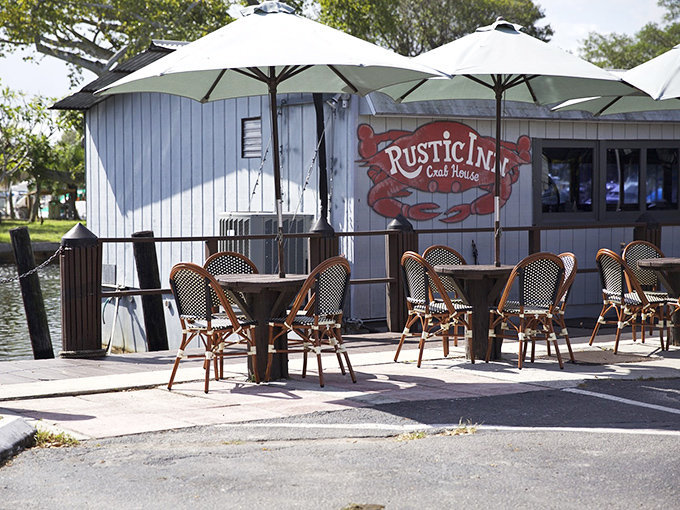 The blue clapboard exterior of Rustic Inn Crabhouse beckons like a siren song to seafood lovers, promising waterfront dining and legendary garlic crabs.
