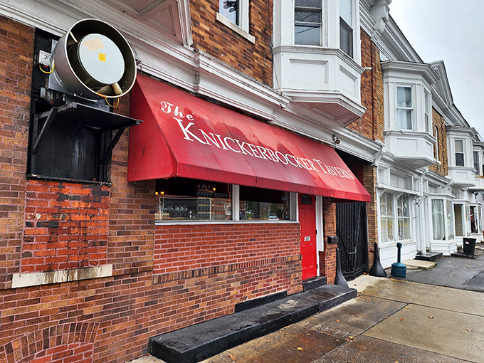 The historic 1904 building stands like a sentinel of good taste at the corner, its red awning beckoning hungry travelers with promises of comfort food glory.