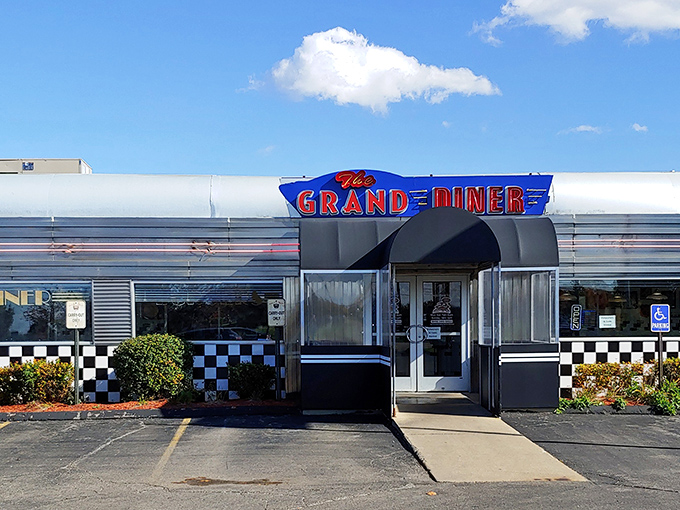 The gleaming stainless steel exterior of The Grand Diner stands like a time machine in Novi, promising nostalgic flavors with that unmistakable neon glow.