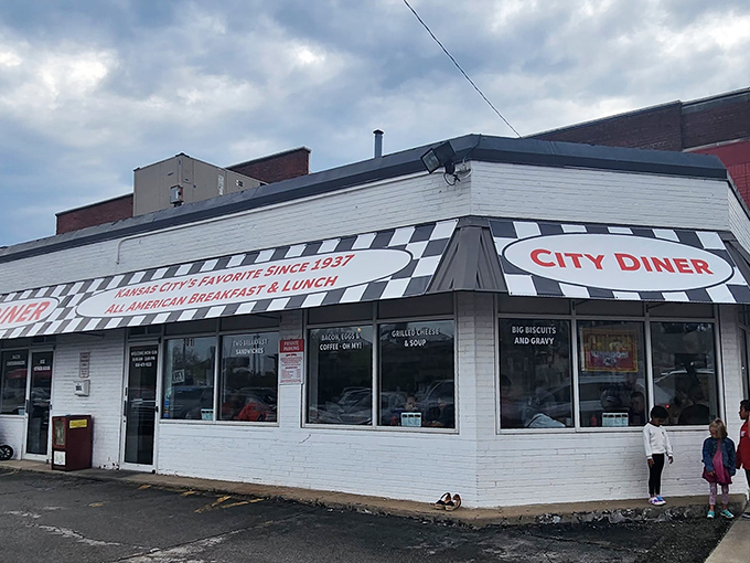 The classic black and white checkerboard trim frames City Diner's bold red signage like a culinary chess match where everyone wins&mdash;especially your appetite.