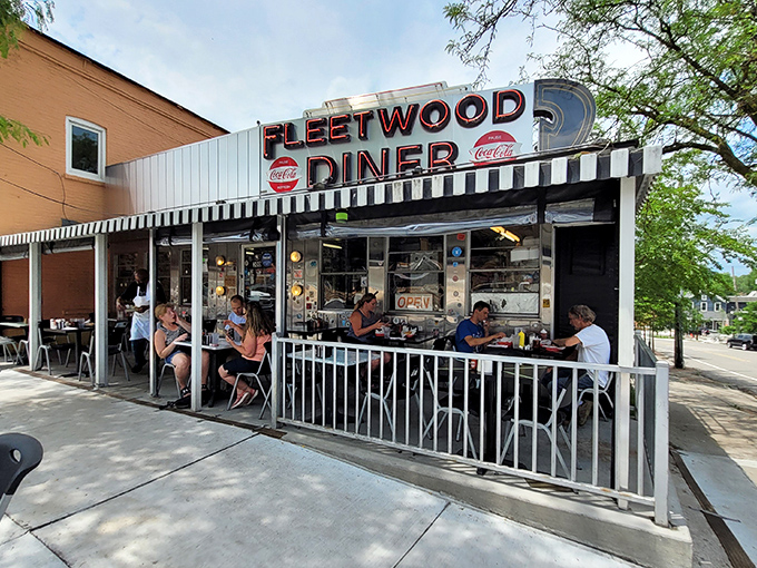 The silver exterior of Fleetwood Diner gleams like a beacon of hope for the hungry, its classic black and white awning promising timeless comfort food within.