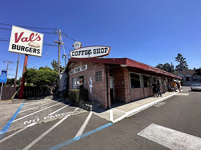 The classic mid-century sign beckons like a time-traveling invitation. Val's Burgers stands proudly against the California sky, promising honest food and zero pretension.