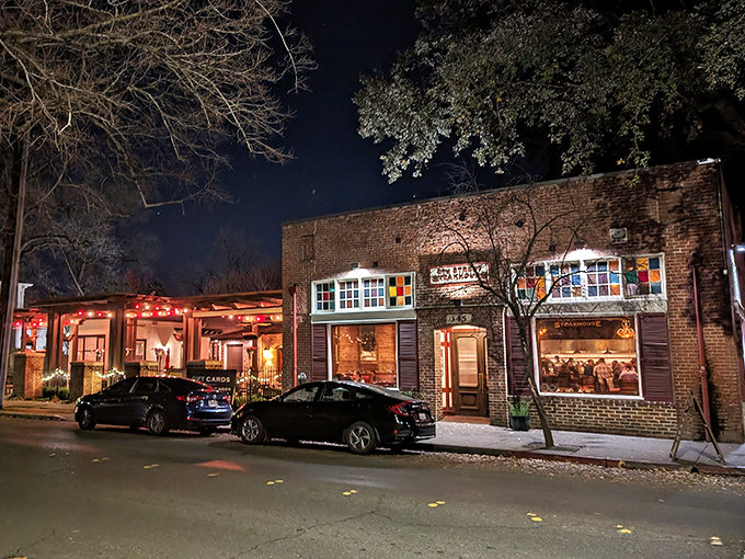 As night falls, this unassuming brick building transforms into a beacon for beef lovers, its warm glow practically whispering "come get your steak on."