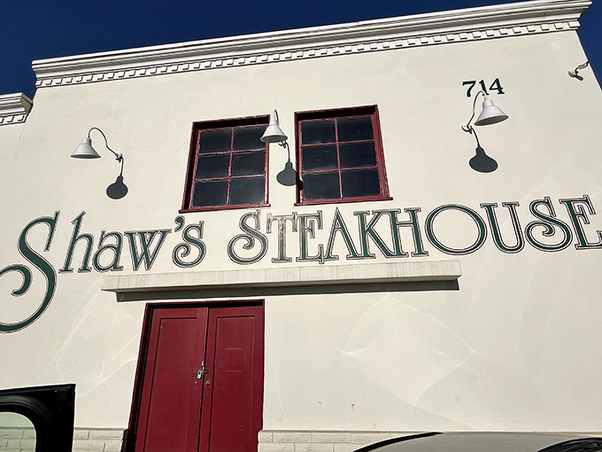 The white facade with bold green lettering and red doors isn't just a restaurant entrance&mdash;it's a portal to California's beef heritage.