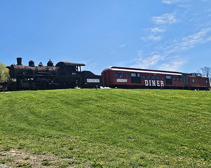 All aboard for flavor! The scarlet railcar of Buckeye Express Diner gleams against the Ohio sky, promising a journey through comfort food paradise.