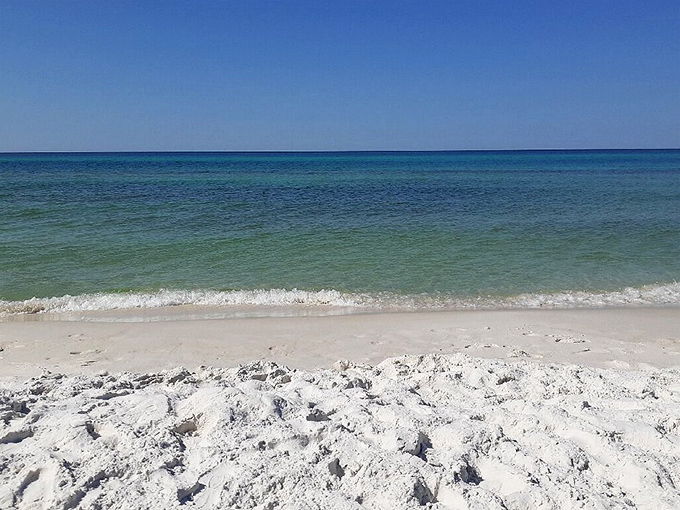 Nature's own watercolor masterpiece. The sunset paints cotton candy clouds over emerald waters while sea oats stand guard like nature's velvet rope. 