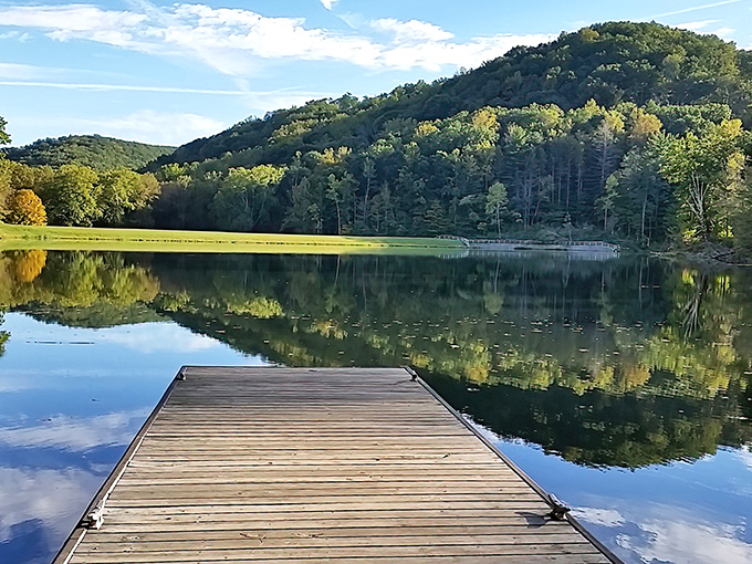 Nature's perfect mirror act. Pine Lake's glassy surface doubles the beauty of Ohio's hidden wilderness, with that wooden dock practically begging for a morning coffee companion. 