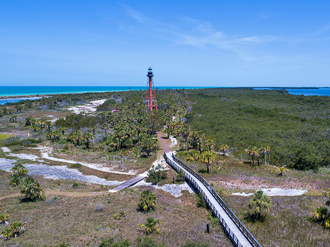 The iconic Anclote Key Lighthouse stands tall among swaying palms, a rusty-red sentinel that's been guiding mariners and Instagram feeds since 1887.