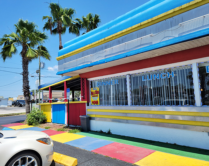 The rainbow-colored exterior of Americana 50's Diner stands out like a Technicolor dream against Florida's blue sky, promising nostalgic delights within.