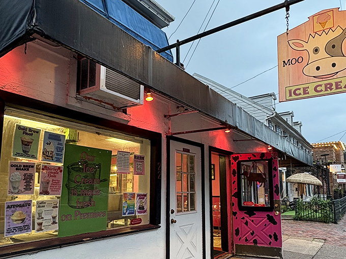 The iconic Moo Hope storefront glows with inviting red lights at dusk, its hot pink door practically begging you to come inside for a scoop of happiness.