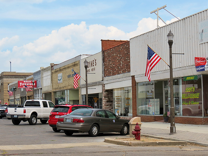 Downtown Kennett welcomes you with classic Americana charm. American flags flutter above storefronts where your dollar stretches like it's 1985.