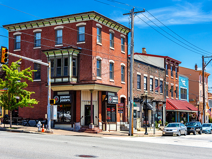 Historic brick buildings with green trim stand sentinel at Conshohocken's corner, where Jimmy John's meets the crossroads of past and present.